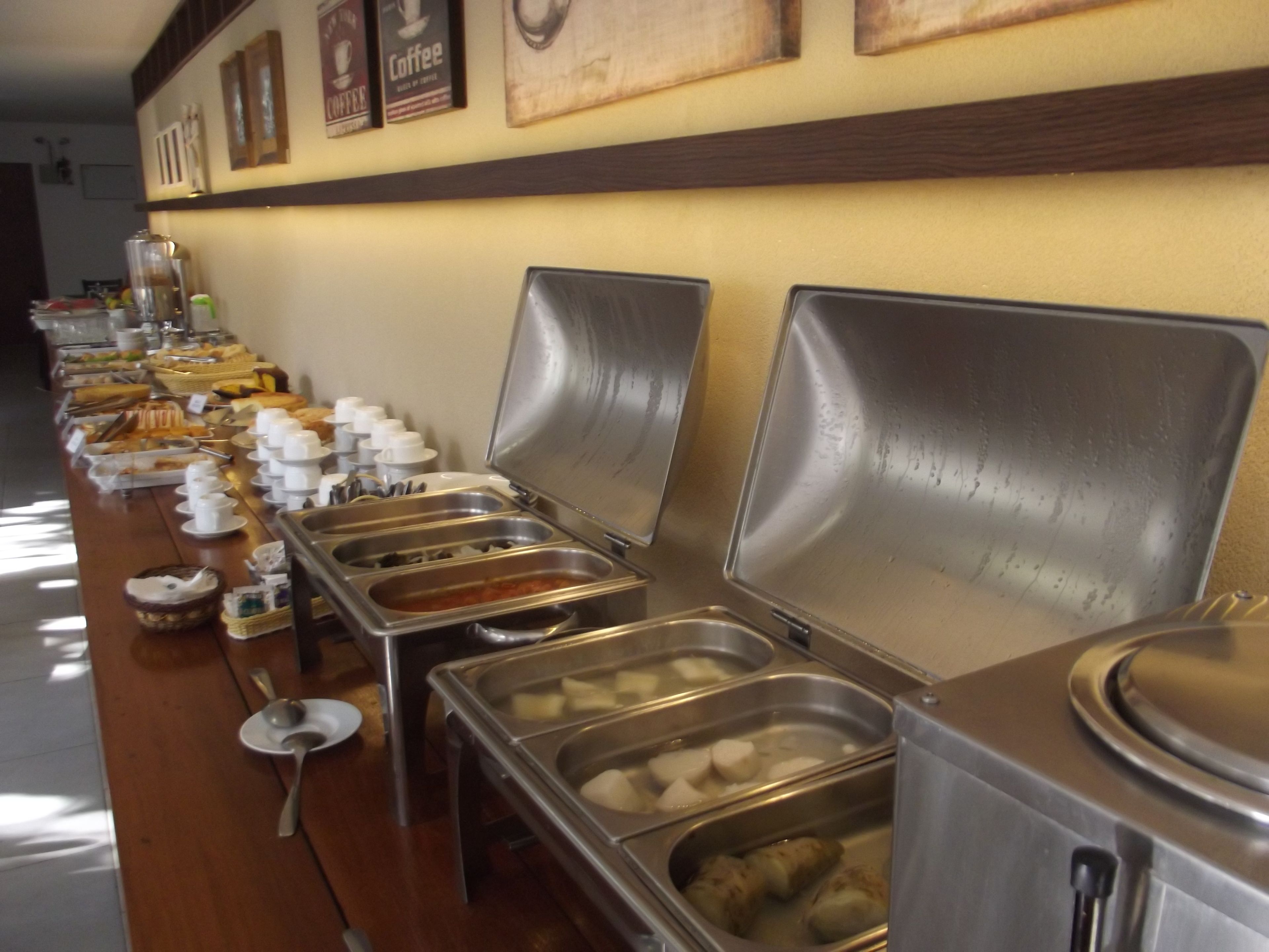 Uma mesa de buffet com diversos alimentos e utensílios.