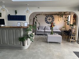 Uma sala de estar moderna com um sofá, uma mesa de centro e uma mesa de recepção.
