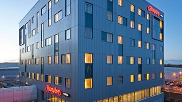 Um hotel moderno com fachada azul e várias janelas.