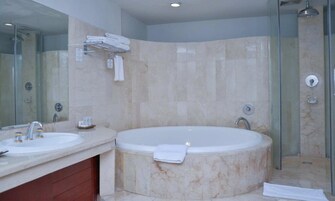 Um banheiro moderno com uma banheira grande, área de chuveiro separada e um lavatório com pia.