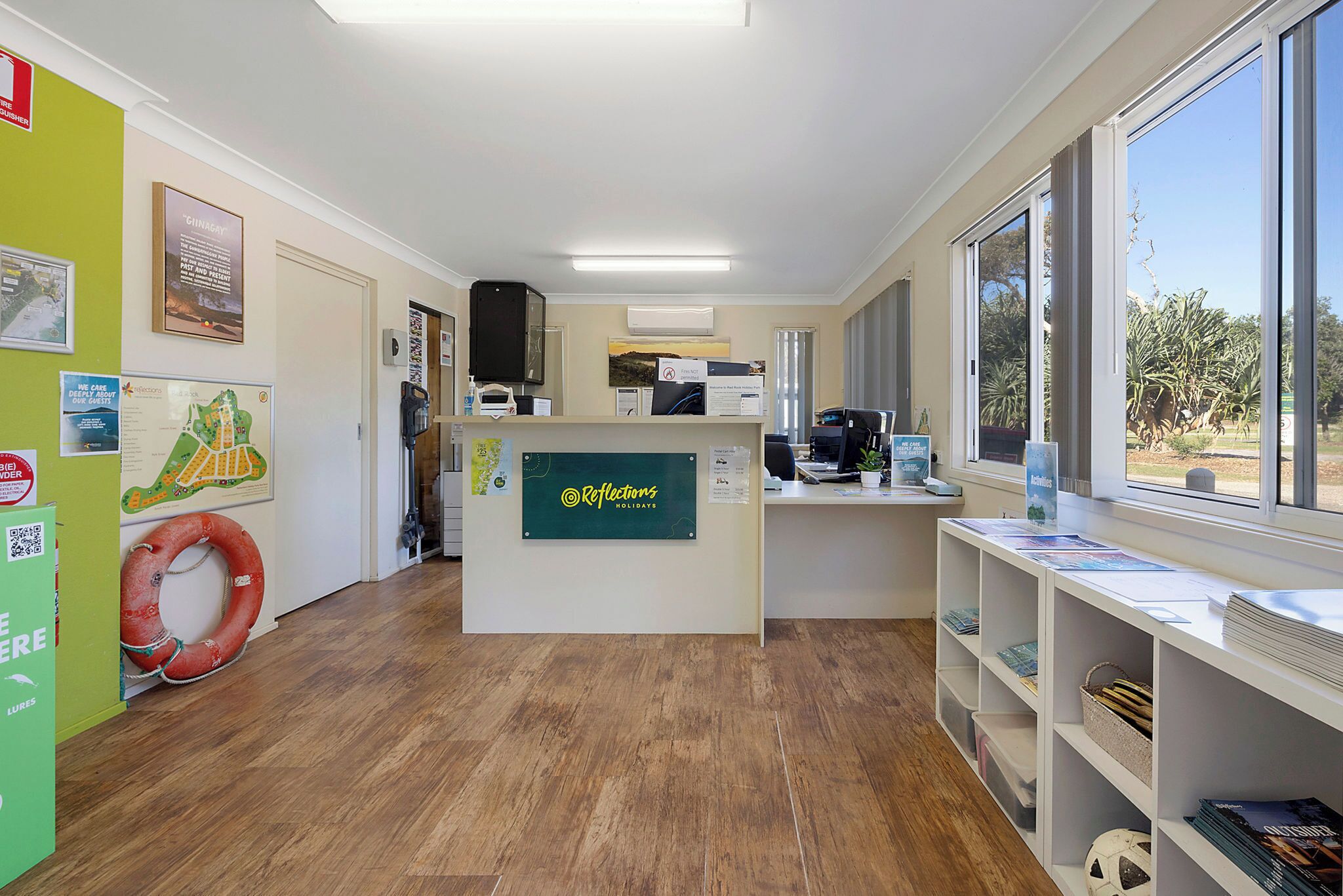 Uma área de recepção com uma mesa, um letreiro com a inscrição 
