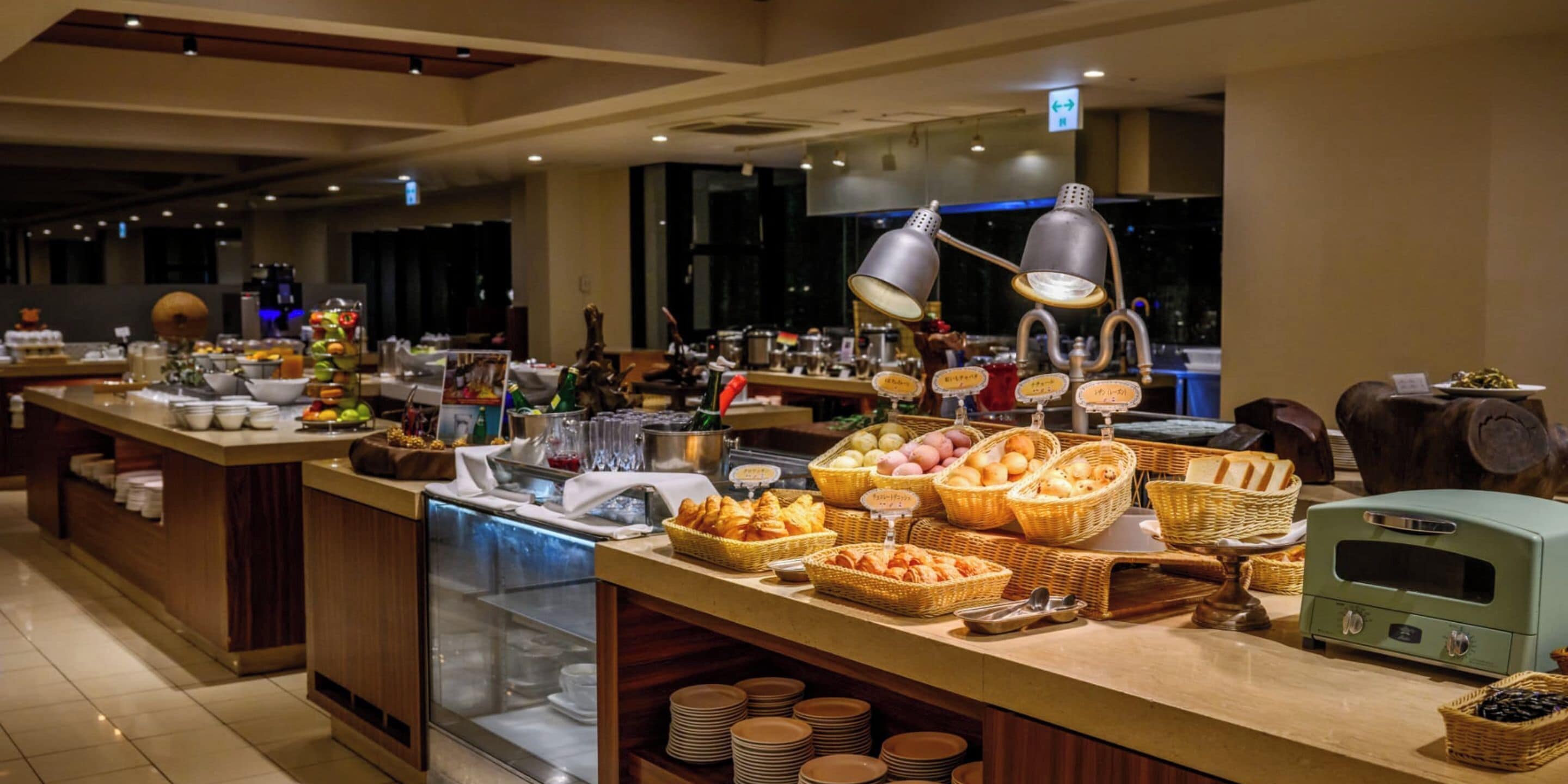 Buffet com diversos tipos de comida, um espaço para bebidas por autoatendimento e um forno pequeno.