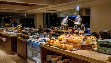 Buffet com diversos tipos de comida, um espaço para bebidas por autoatendimento e um forno pequeno.