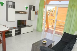 Apartamento Superior, 1 quarto, terraço, vista para a piscina | Sala | TV de ecrã plano, ténis de mesa, livros 
