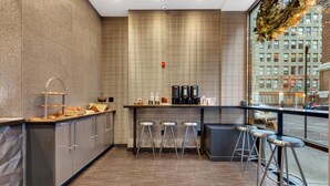 Uma área de bar moderna com balcão, banquetas e vista para a cidade através de amplas janelas.