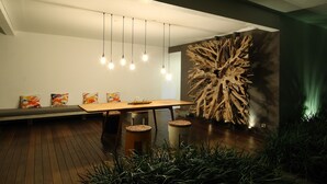 Uma área de jantar moderna com mesa de madeira, luminárias pendentes e uma obra de arte original na parede.
