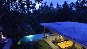 Um pátio moderno ao ar livre com piscina, espreguiçadeiras e área de refeições.