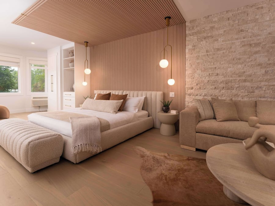 Quarto moderno com uma cama grande, um sofá e uma escultura decorativa.