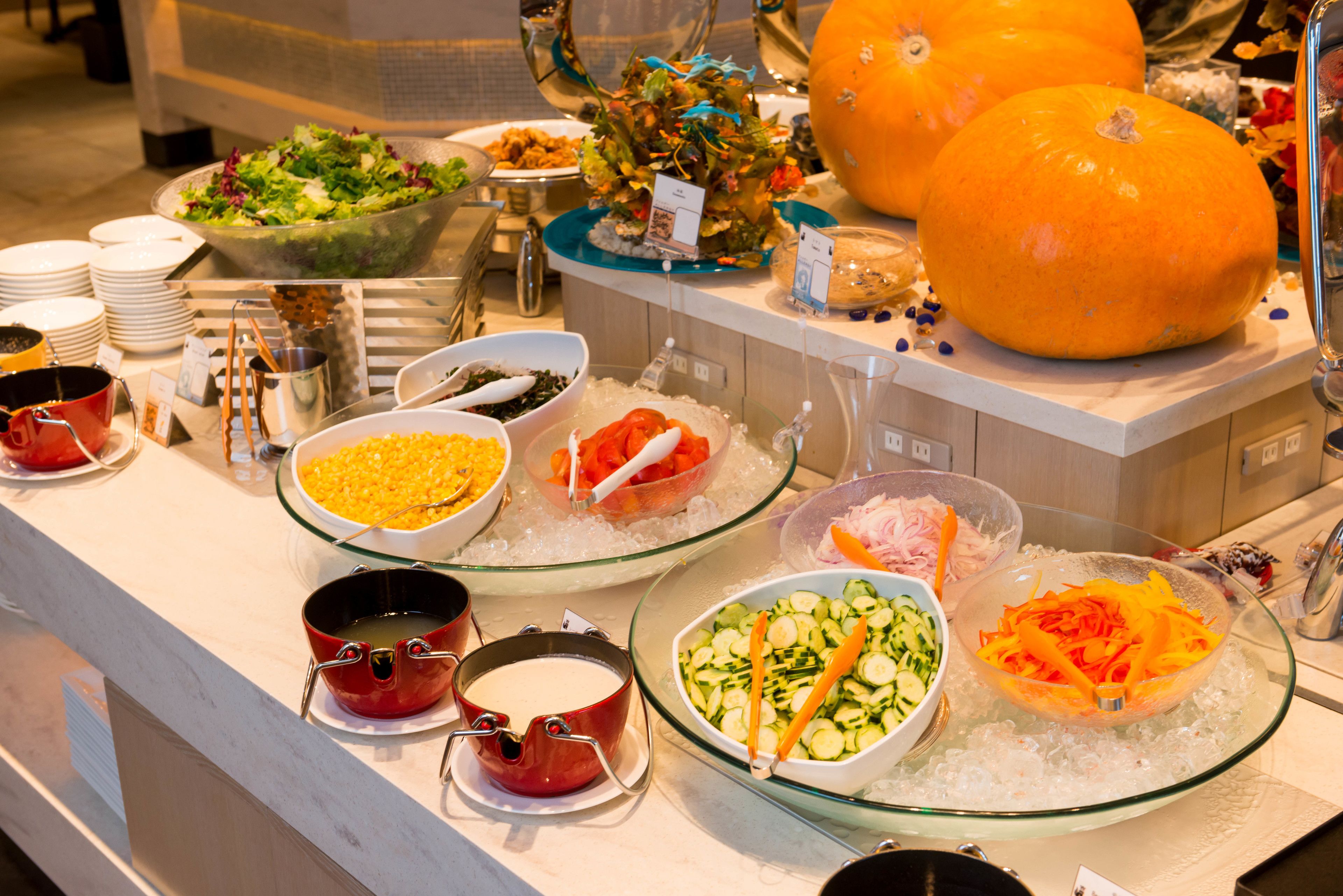 Um buffet com diversos alimentos e bebidas dispostos em um balcão.