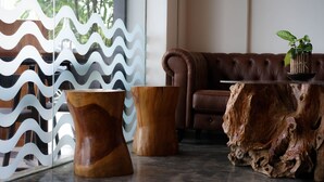 Um interior moderno com um sofá de couro marrom, uma mesa de centro de madeira e uma base de toranzo original.