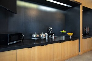 Uma cozinha moderna com bancada preta, eletrodomésticos de aço inoxidável e armários de madeira.