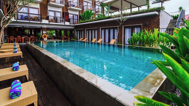 Piscina com espreguiçadeiras e um bar.