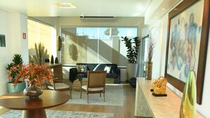Uma sala de estar moderna com sofá, cadeiras, mesa de centro e escada que leva a outro andar.