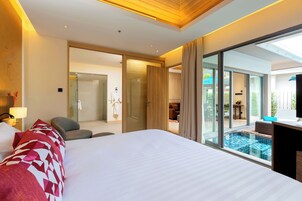 Quarto de hotel com uma cama grande, área de estar, porta de vidro que dá para uma varanda e uma piscina pequena.