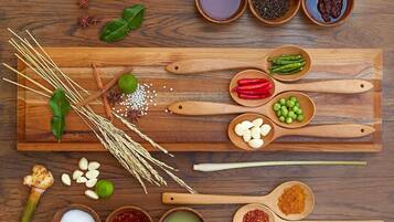 Uma tábua de corte de madeira com diversos temperos e ingredientes.