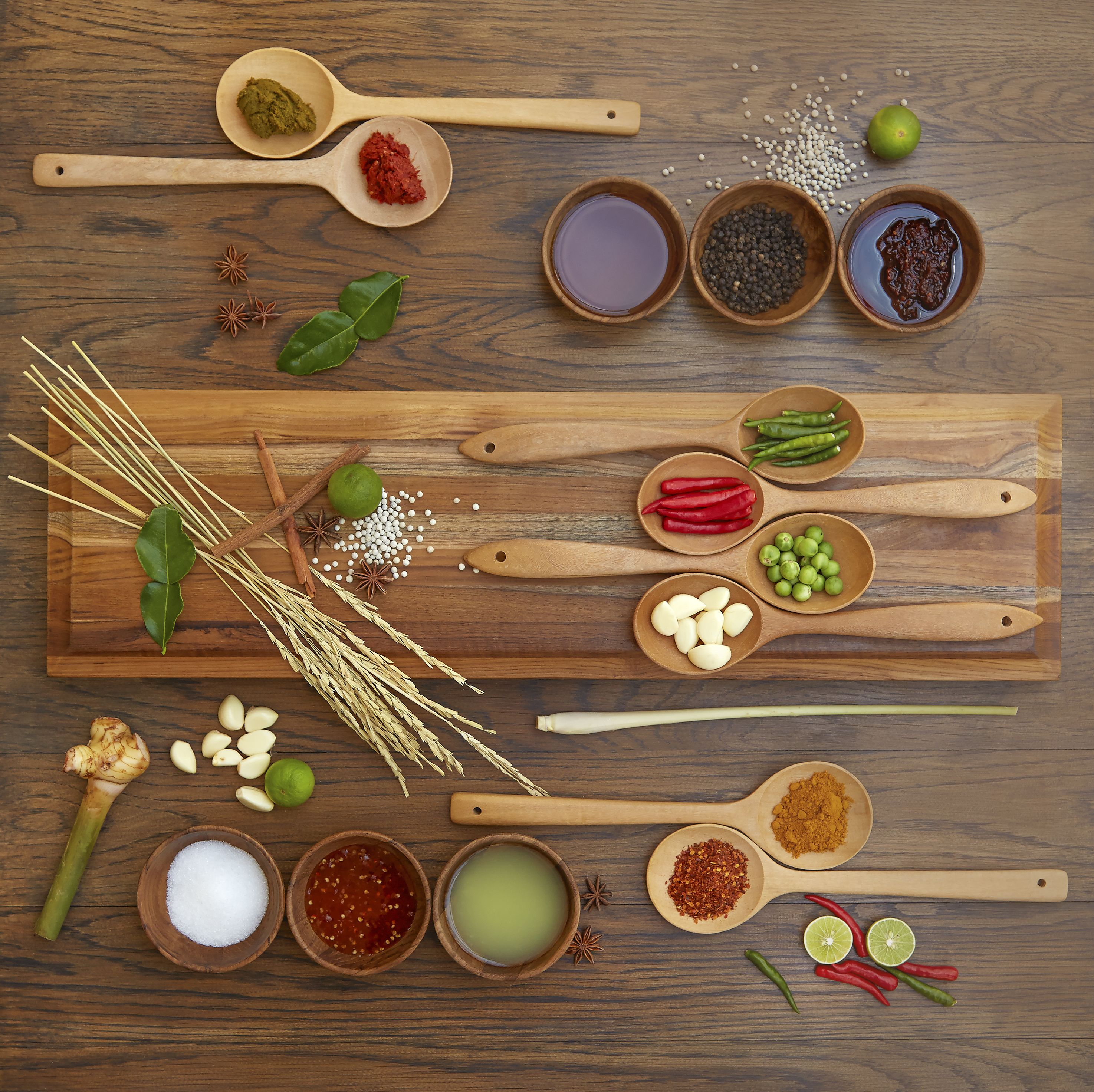 Uma tábua de corte de madeira com diversos temperos e ingredientes.