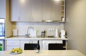 Um frigorífico/congelador grande, um micro-ondas, uma placa de cozinha 