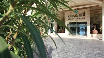 Um edifício com uma placa indicando "Aitana Khasab" e uma entrada de vidro.