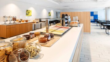 Uma área de buffet com diversos alimentos e acompanhamentos.