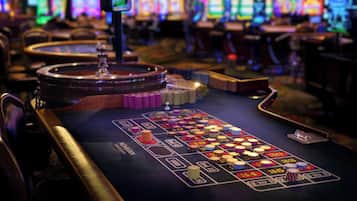 Uma mesa de casino com fichas e uma roleta.