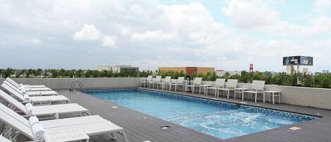 Uma piscina no terraço com espreguiçadeiras e um toboágua.