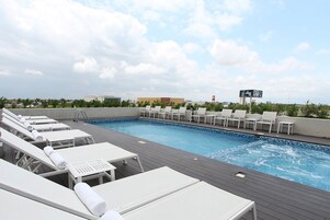 Uma área de piscina no terraço com espreguiçadeiras e piscina.