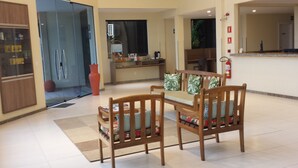 Uma sala ampla com conjunto de jantar de madeira e um sofá.