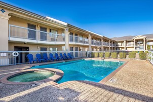 Um hotel com piscina, área de estar ao ar livre e banheira de hidromassagem.