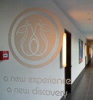 Um corredor com um logotipo circular e o texto 'uma nova experiência, uma nova descoberta'.