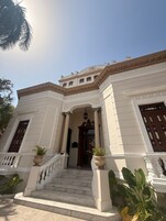Um edifício com uma entrada imponente, escadaria e colunas.