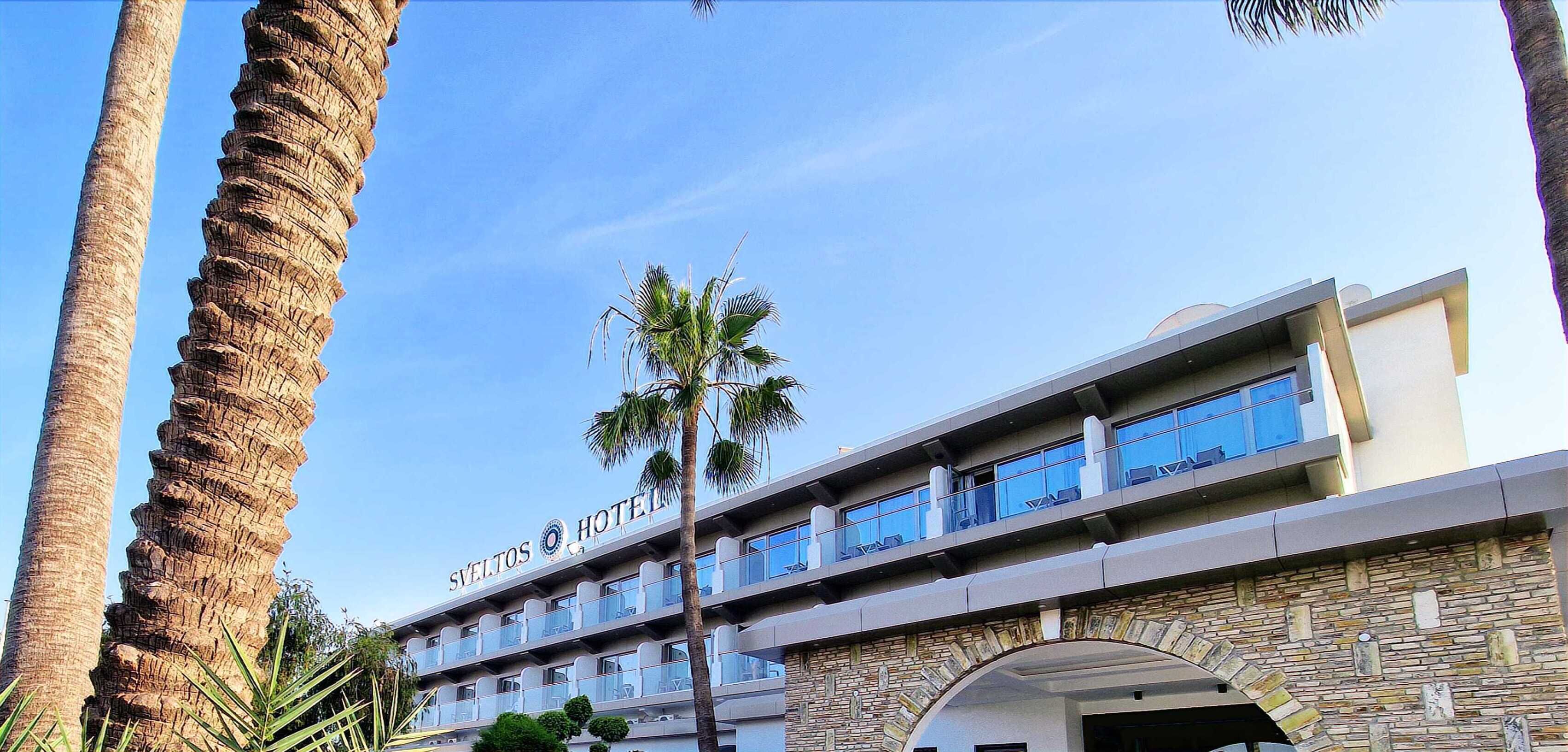 Um hotel com design moderno, fachada em pedra e várias varandas.