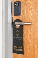 Porta de hotel com um aviso 'NÃO PERTURBE' e leitor de cartão-chave.