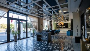 Um lobby moderno com mesa de pebolim, área de estar e bar.