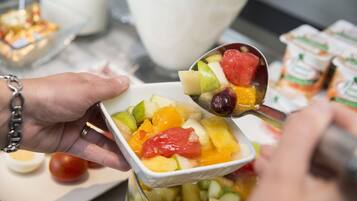 Uma pessoa segurando uma tigela de salada de frutas com uma colher.