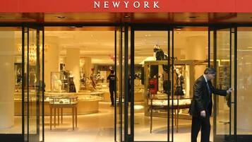 Uma loja Barney's NewYork com manequins exibindo roupas e acessórios.