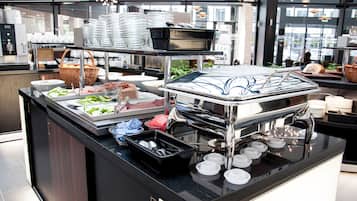 Uma mesa de buffet com diversos alimentos e utensílios.
