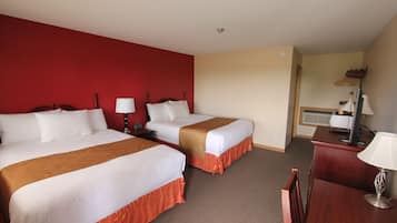 Quarto de hotel com duas camas, uma escrivaninha e uma cadeira.