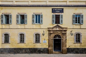 Um edifício com uma placa que diz 'L'IGLESIA Hotel'.