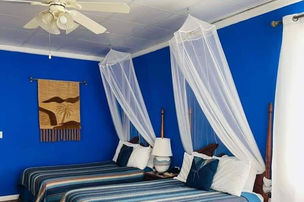 Quarto Deluxe, 2 camas de casal, varanda, vista parcial para o mar | 1 quarto, roupa hipoalergénica, edredões de penas