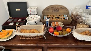 Buffet de café da manhã com diversos alimentos e um espaço para café.