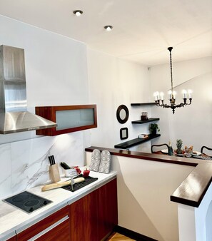 Apartamento | Cozinha privada | Geladeira, cooktop, talheres/pratos/utensílios de cozinha, freezer