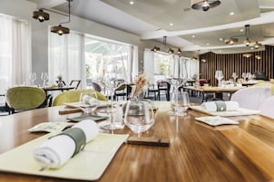 Restaurante com mesas de madeira, copos de vidro transparente e design de interiores moderno.