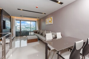 Uma sala de estar moderna com um sofá, uma mesa de jantar e uma televisão.