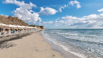 Uma praia privada, praia de areia negra, espreguiçadeiras