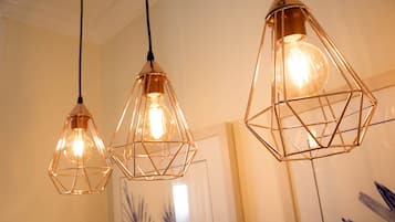 Três luminárias pendentes geométricas com lâmpadas aparentes suspensas no teto.