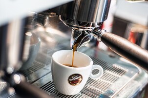 Máquina de café servindo café em uma xícara.