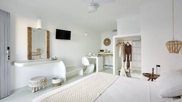 Quarto moderno com uma cama grande, uma penteadeira com espelho, uma escrivaninha e um closet espaçoso.