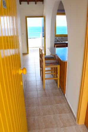 Corredor que dá para uma cozinha com vista para o mar.