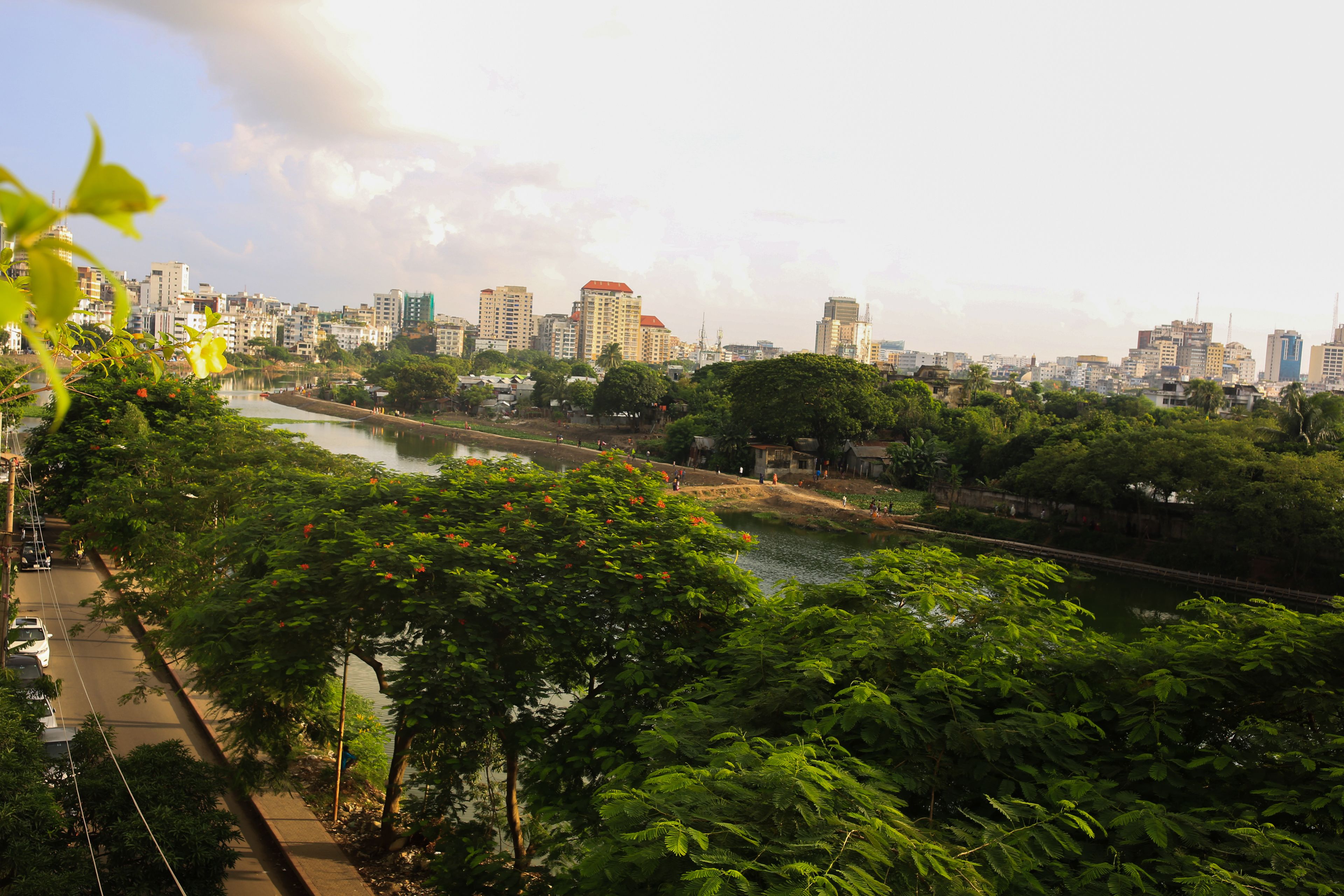 Paisagem urbana com rio, vegetação e edifícios.