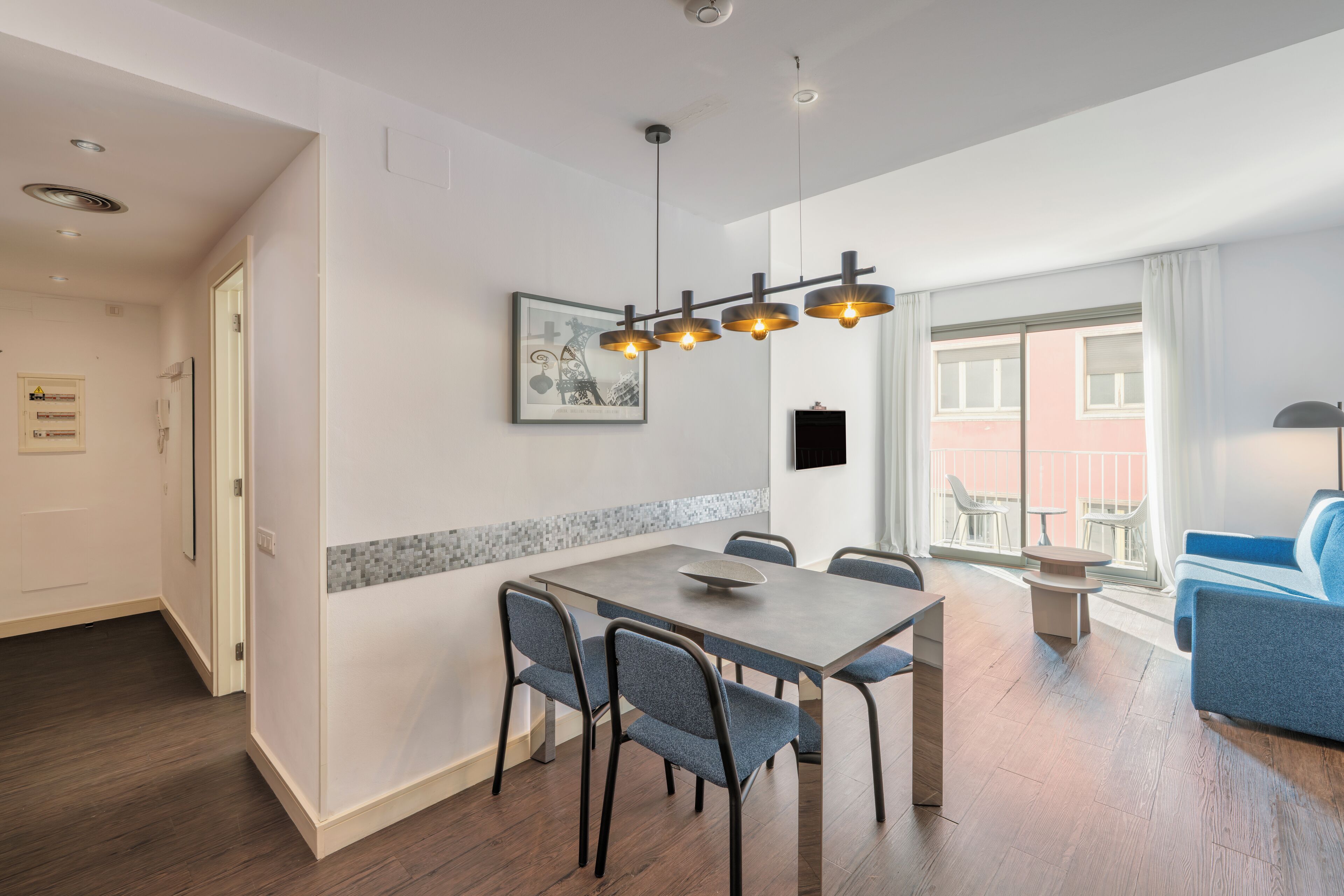 Cozinha moderna com mesa de jantar, cadeiras e iluminação pendente.